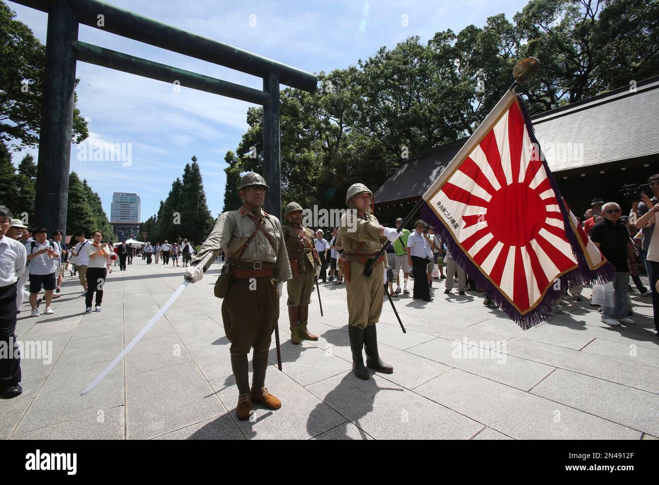 Japanese men clad in outdated military costume march in to pay respects ...