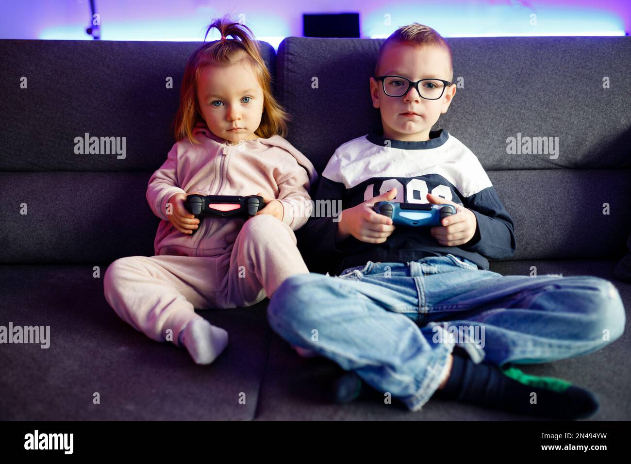 The boy Danya and his younger sister Emilia play on the console Stock ...