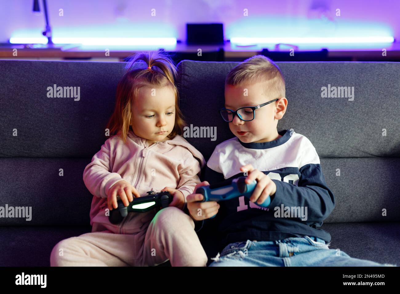 The boy Danya and his younger sister Emilia play on the console Stock ...