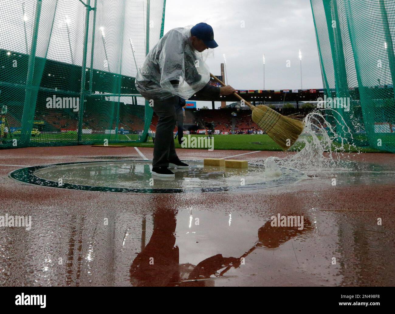 A man wipes away water from the hammer throw ring during the European ...