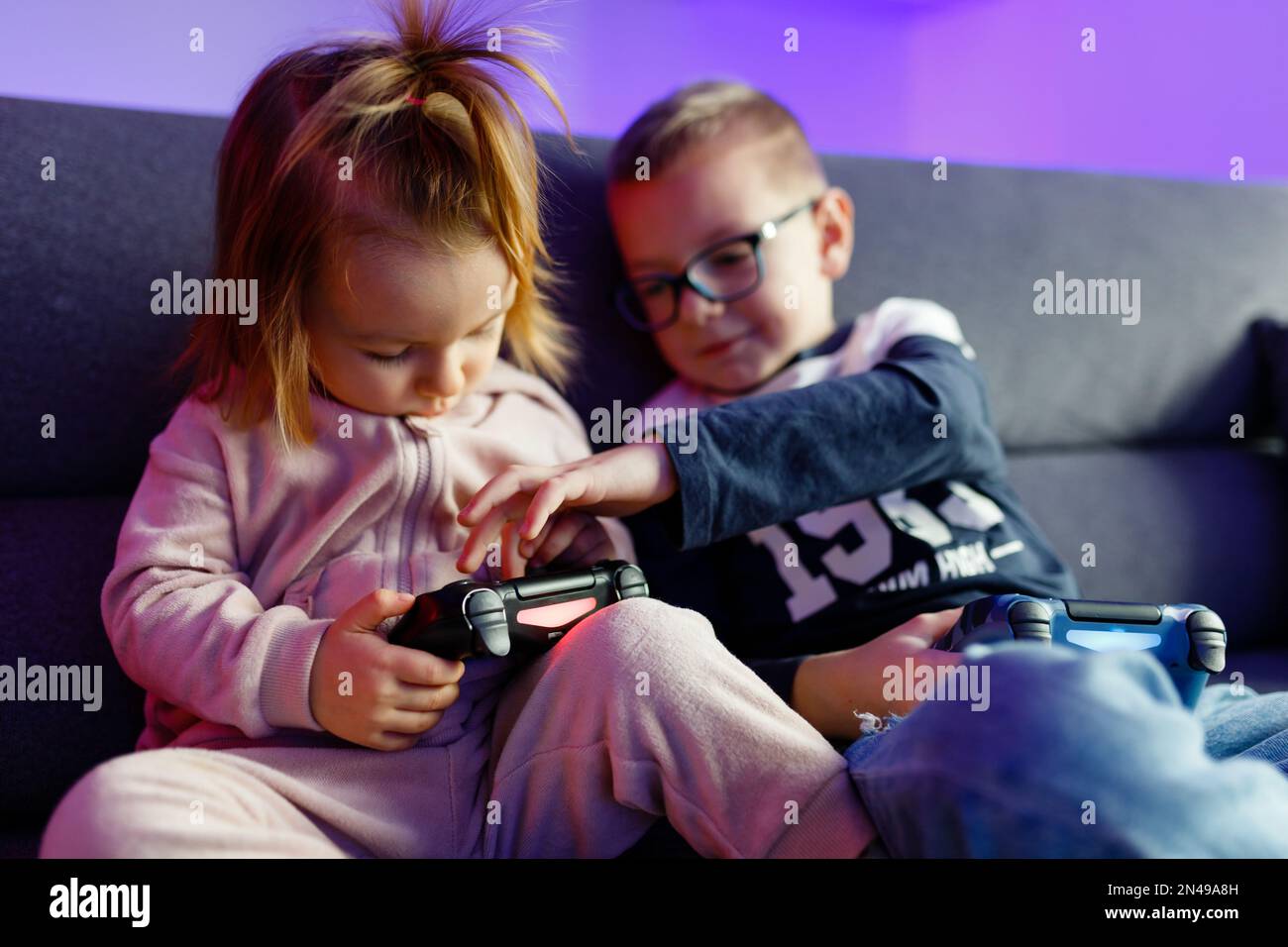 The boy Danya and his younger sister Emilia play on the console Stock ...