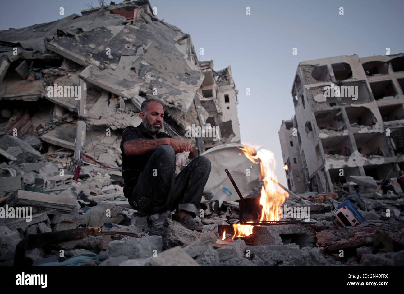 Palestinian Ziad Rizk, 38, makes coffee next to one of the destroyed ...