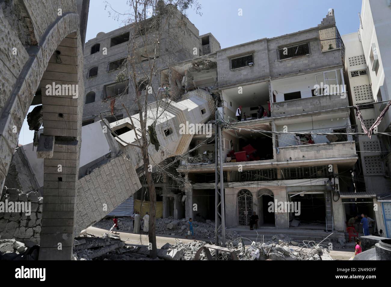 Palestinians inspect damages to adjacent houses from a fallen minaret ...