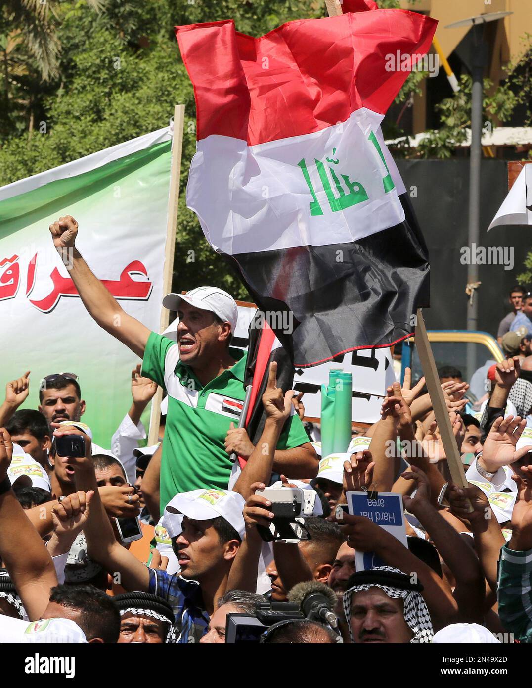 Iraqis chant pro-government slogans and wave national flags, to show ...