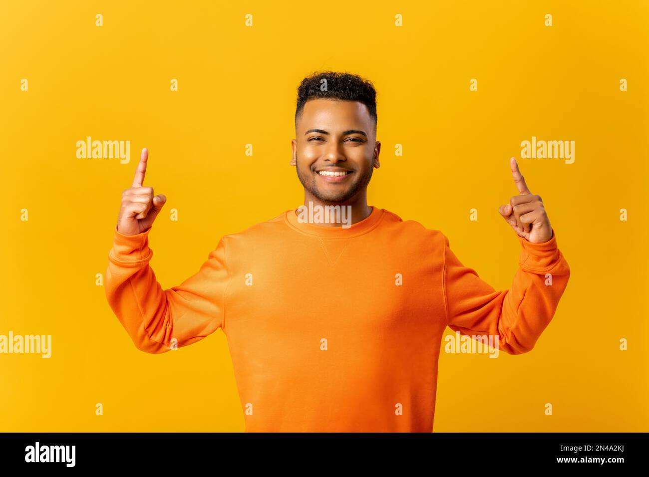 Attractive indian man with overjoyed facial expression pointing up with ...