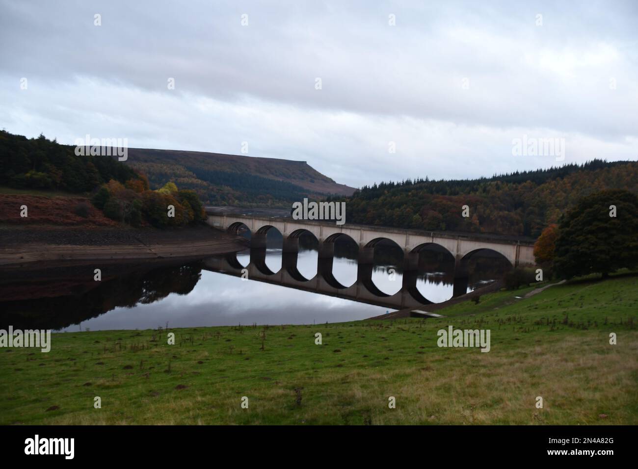 The arch-like bridge over Ladybower Reservoir with lush trees in ...