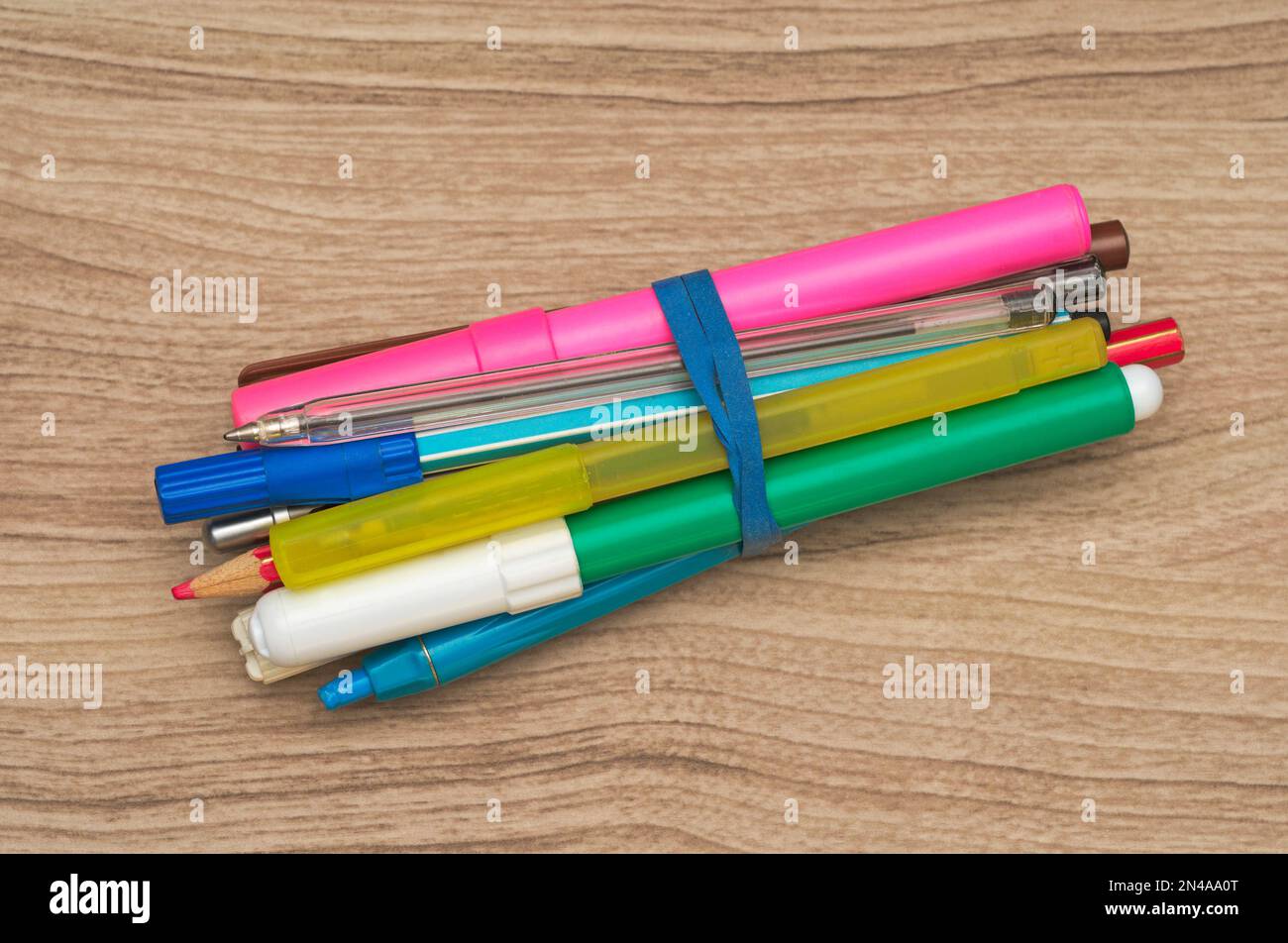 different pens and markers tied with rubber band Stock Photo - Alamy