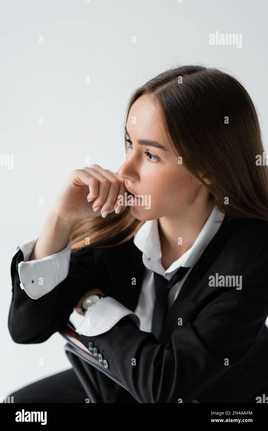 overhead view of dreamy woman with long hair sitting in suit and ...