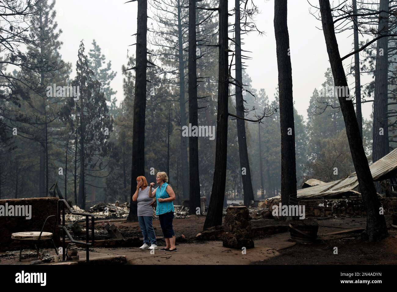 Monique Kane, left, and Lynn Westerlund look around a fire-ravaged ...