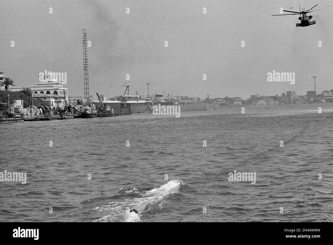 A U.S. Sea Stallion helicopter takes off from a dock, past the ...