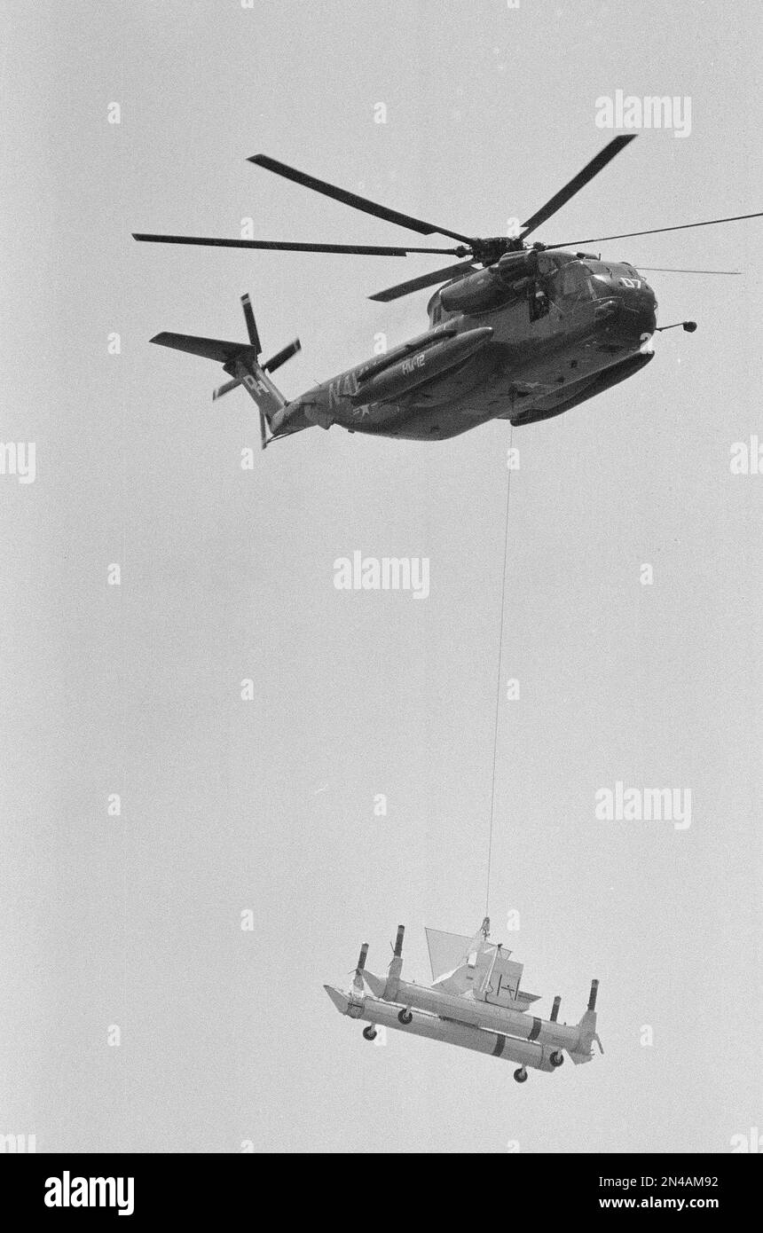 A U.S. Sea Stallion helicopter carries a magnetic mine sweeping device ...