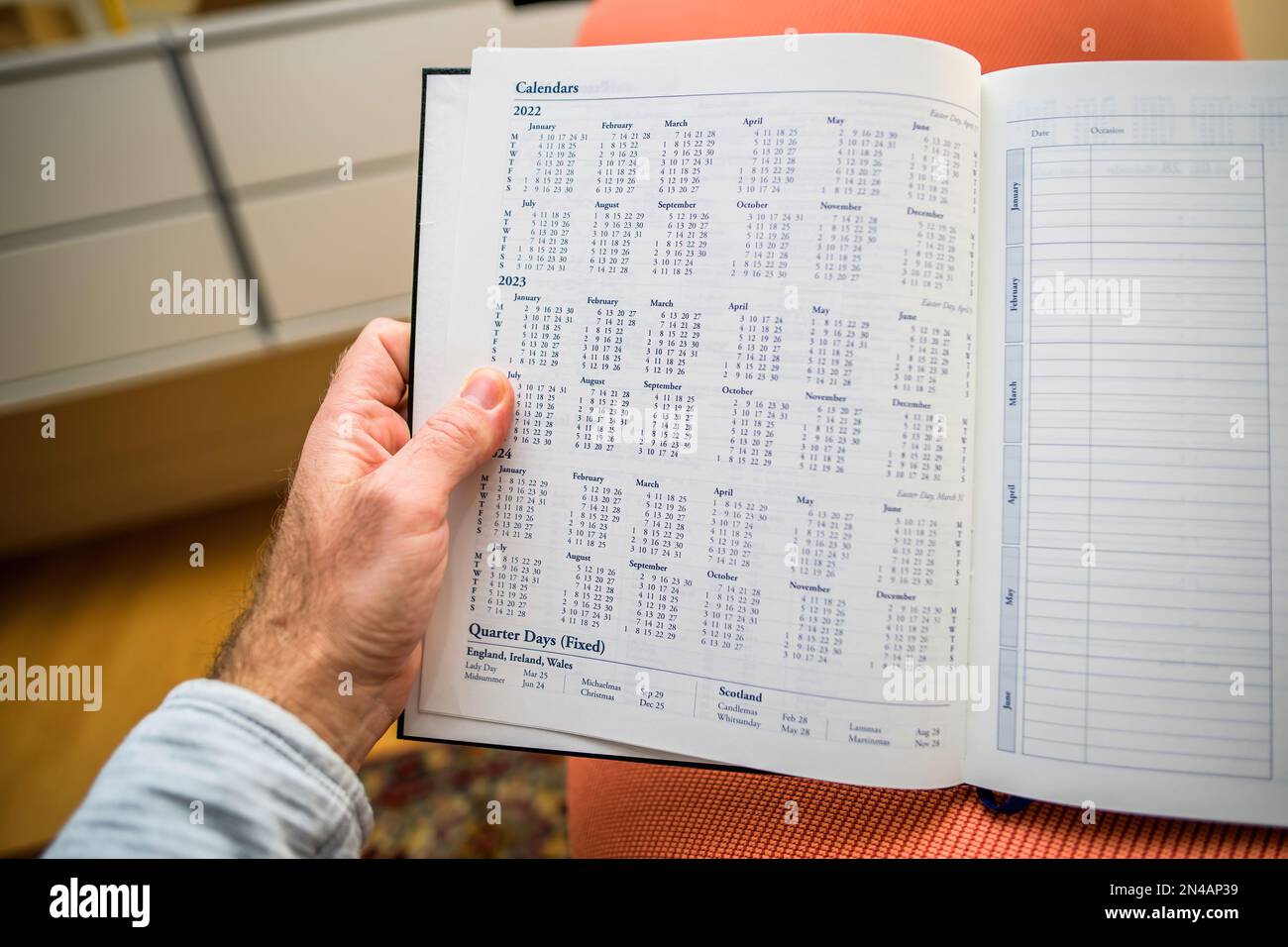 Male hand holding annual agenda with Calendar for 2022, 2023 and 2024 ...