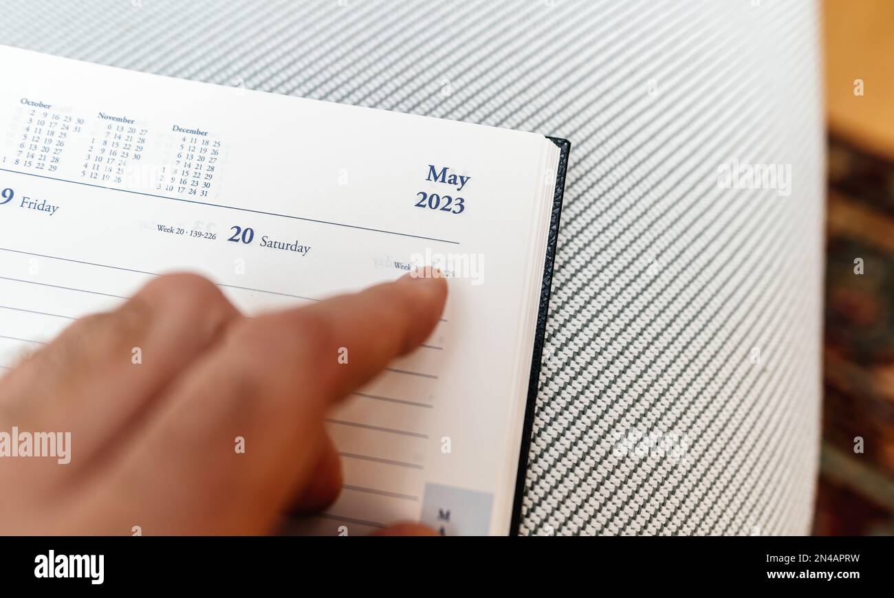 New 2023 year business planner agenda with male hand pointing to May ...