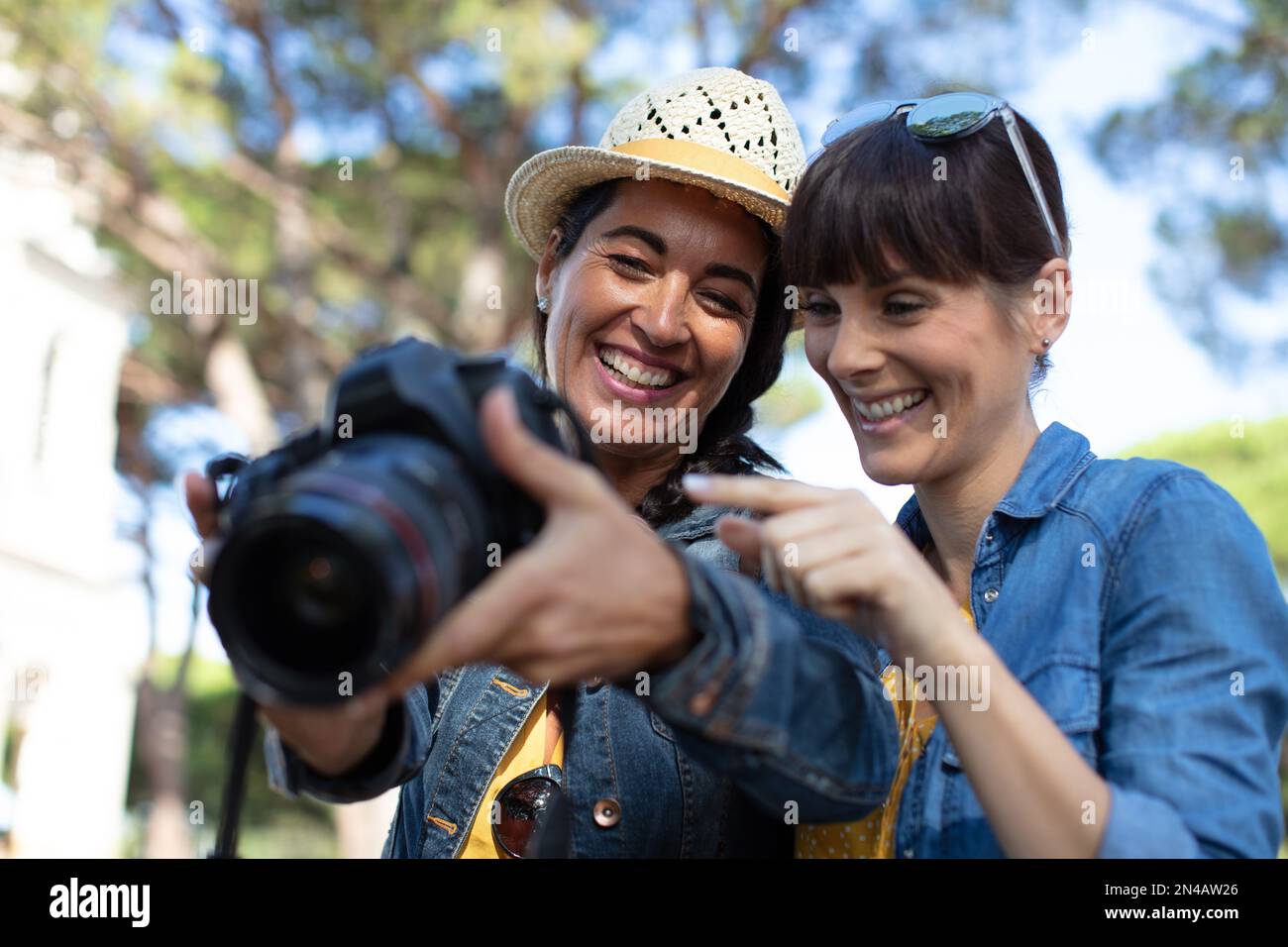 female friends using a dslr while on vacation Stock Photo - Alamy