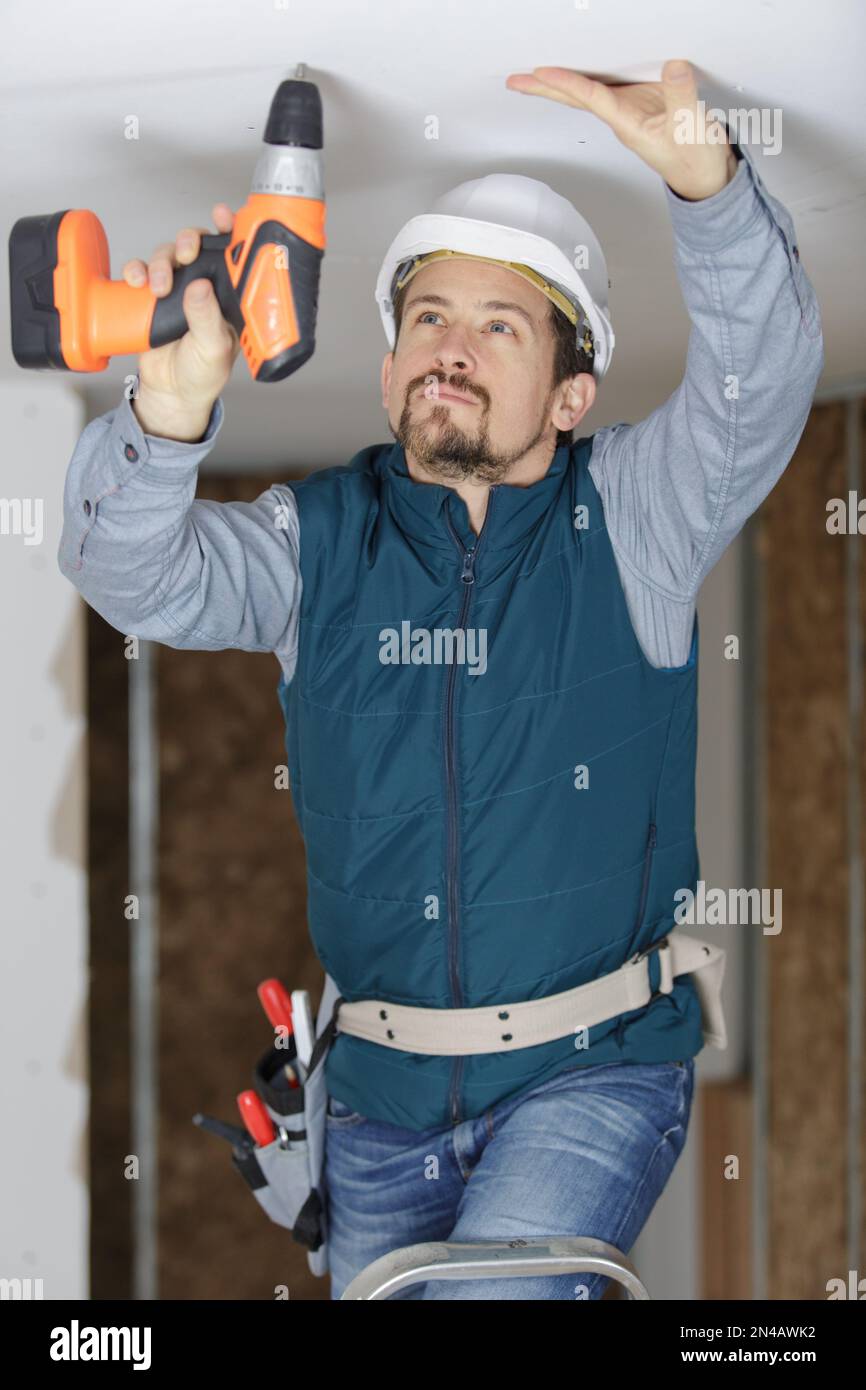 young man fixing drywall suspended ceiling Stock Photo - Alamy