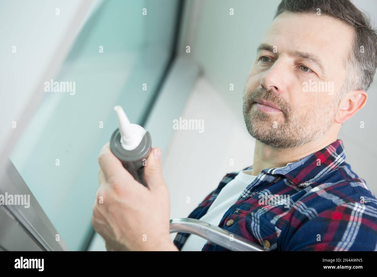 man with silicone sealant and caulking gun in hands Stock Photo - Alamy