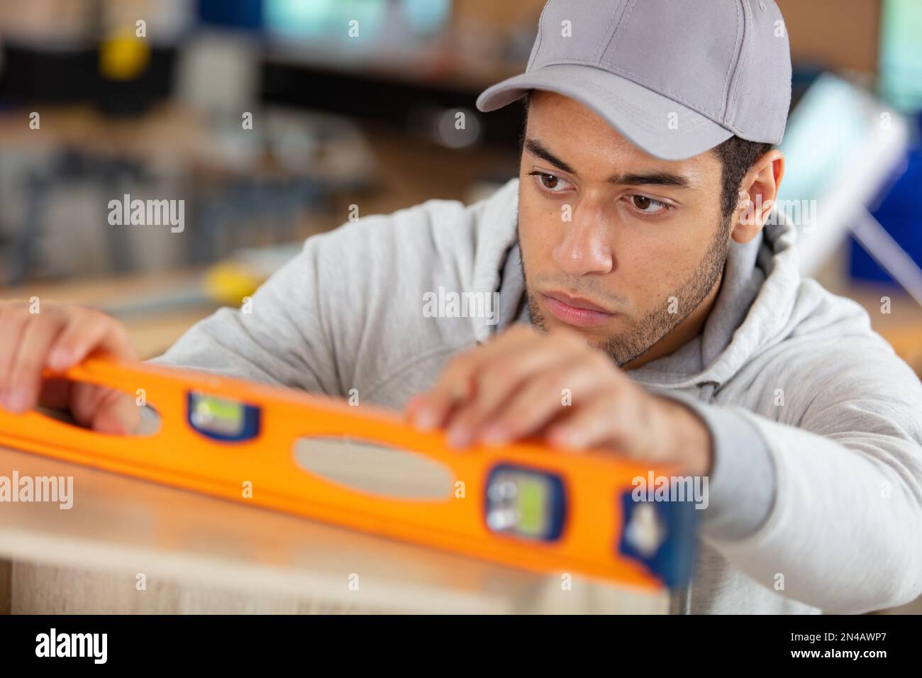 worker using spirit level against workshop Stock Photo - Alamy