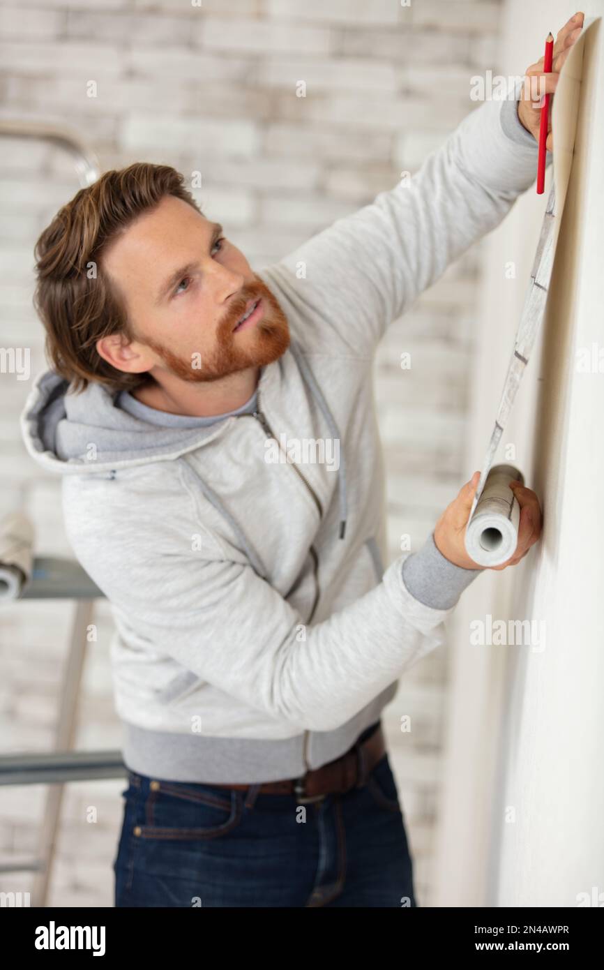 man holding wallpaper sample against wall Stock Photo - Alamy