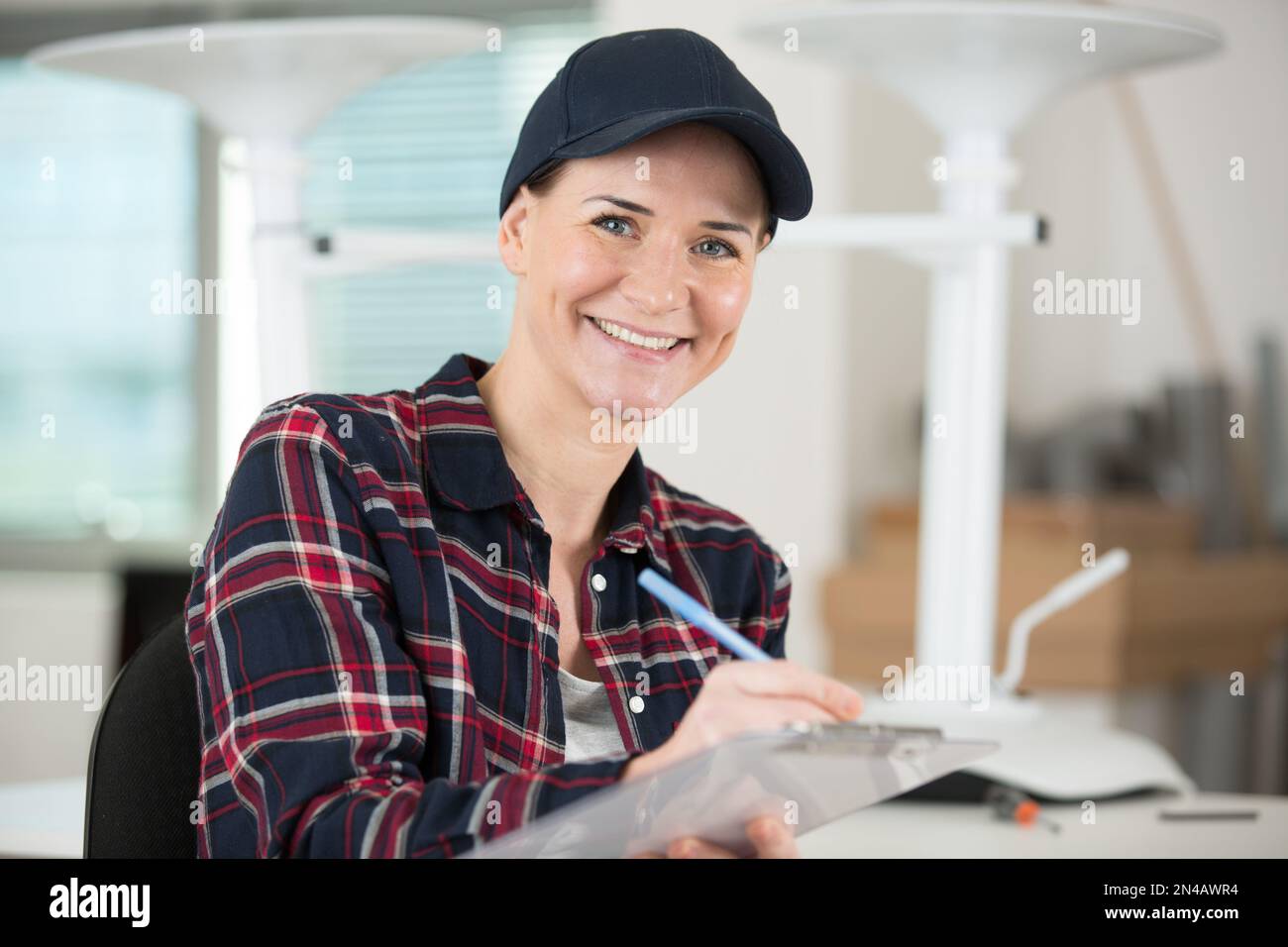 happy female worker after assembling a chair Stock Photo - Alamy
