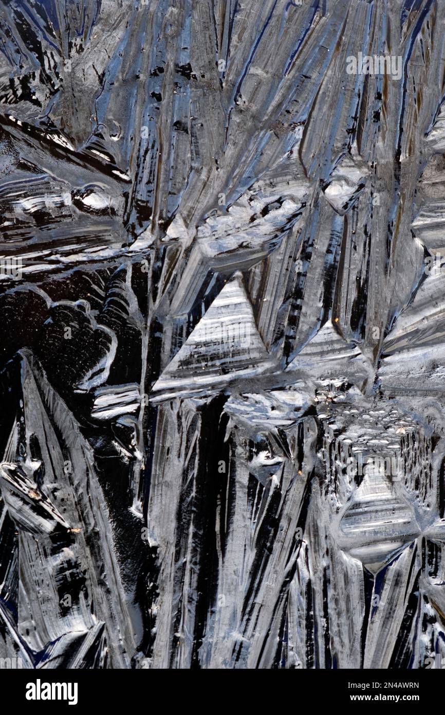 Shards of frozen water ice form patterns look black view from above ...
