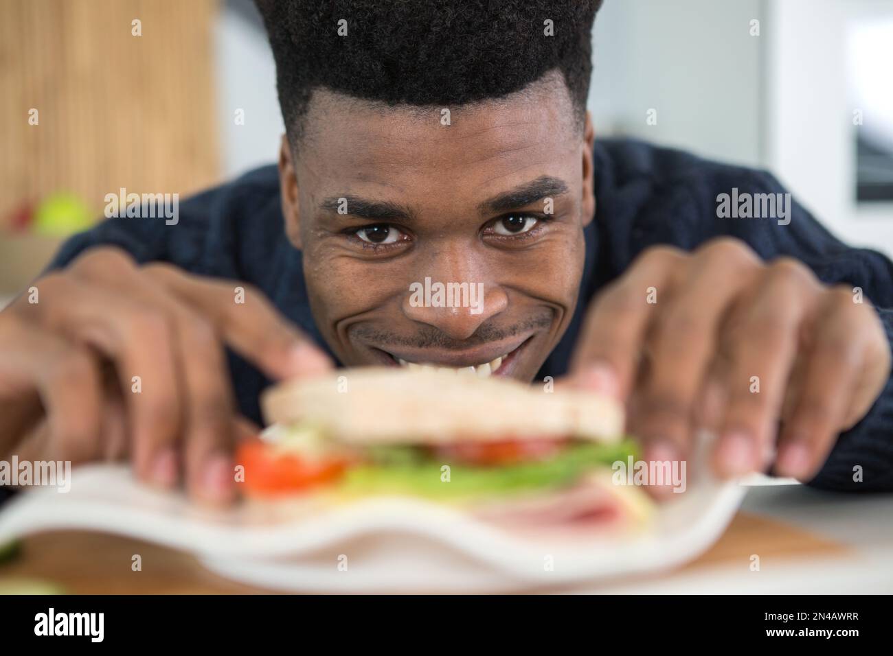 attractive young man eating a sandwich Stock Photo - Alamy
