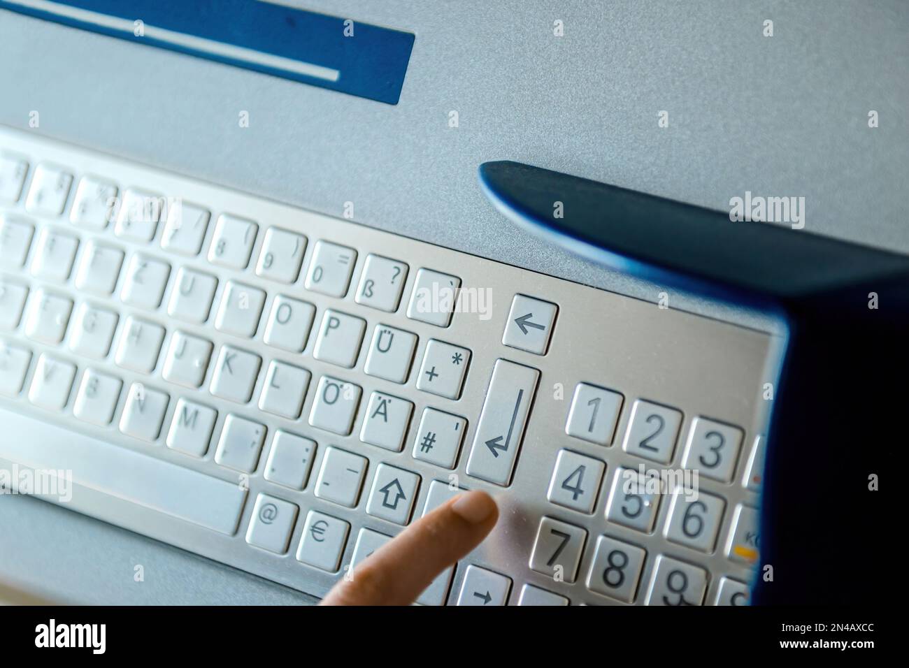 Woman finger pressing enter button on the metallic ATm keyboard with ...