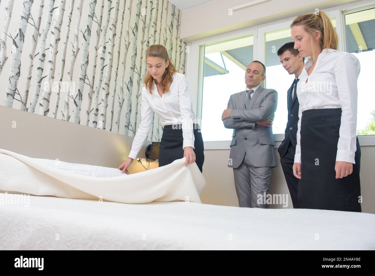 Chamber maid practicing to make up a bed Stock Photo - Alamy