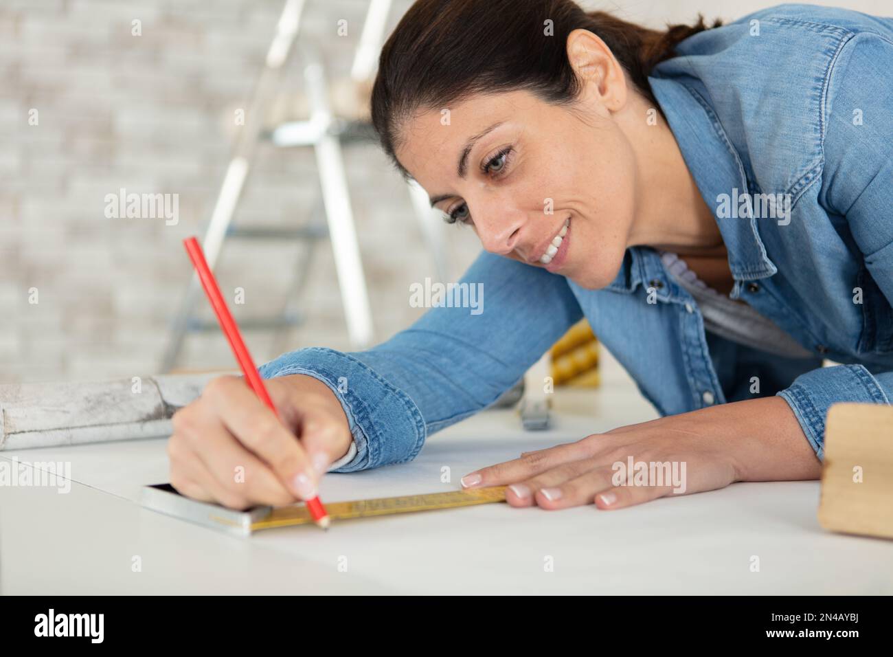 female redecorating using ruler to draw line Stock Photo - Alamy