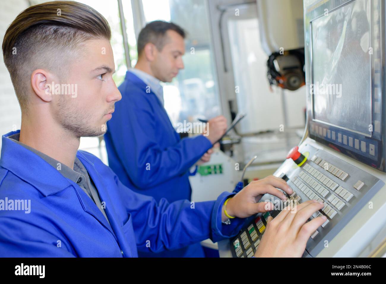 Young operative using computer in factory Stock Photo - Alamy