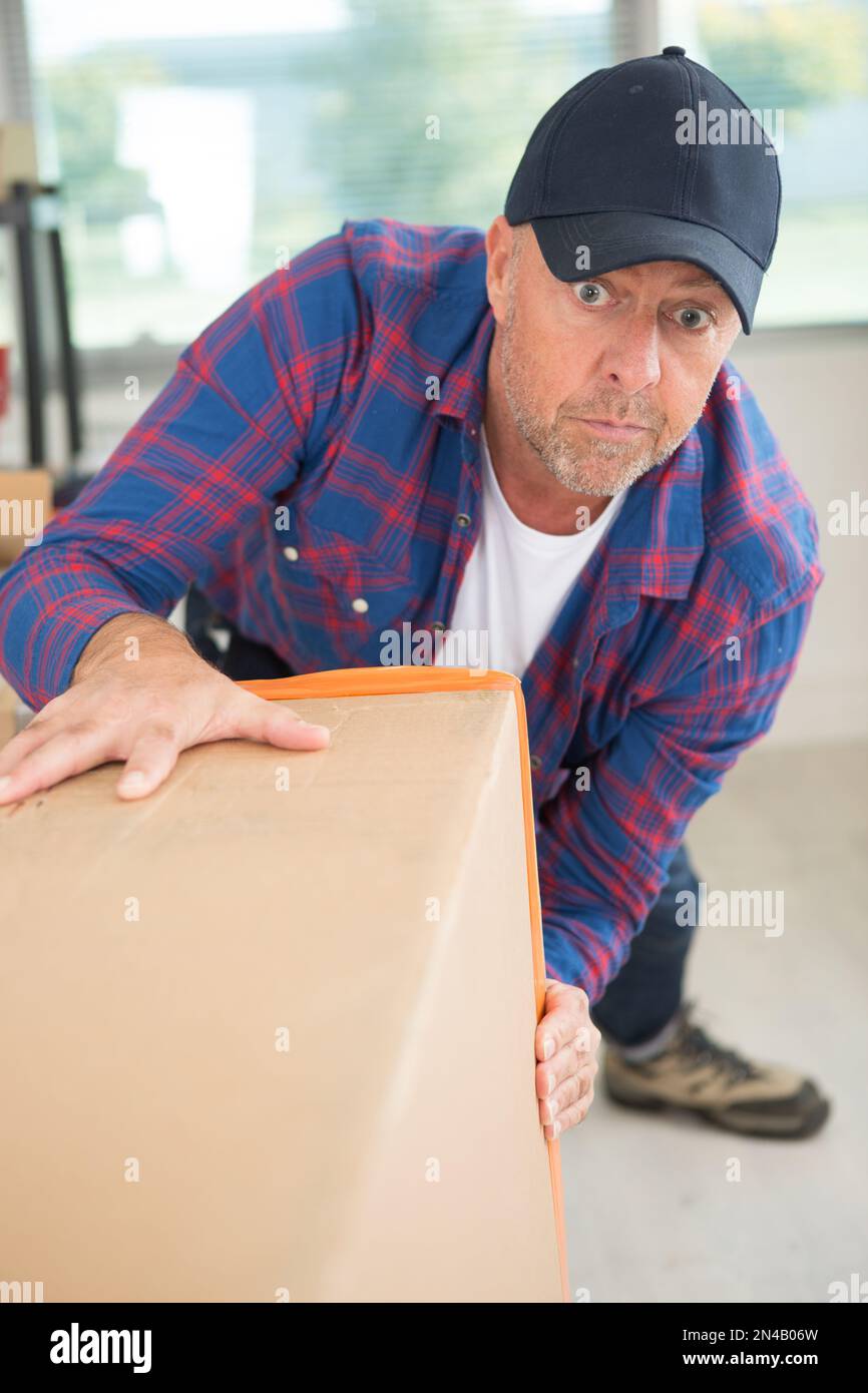 mature man trying to catch a falling box Stock Photo - Alamy