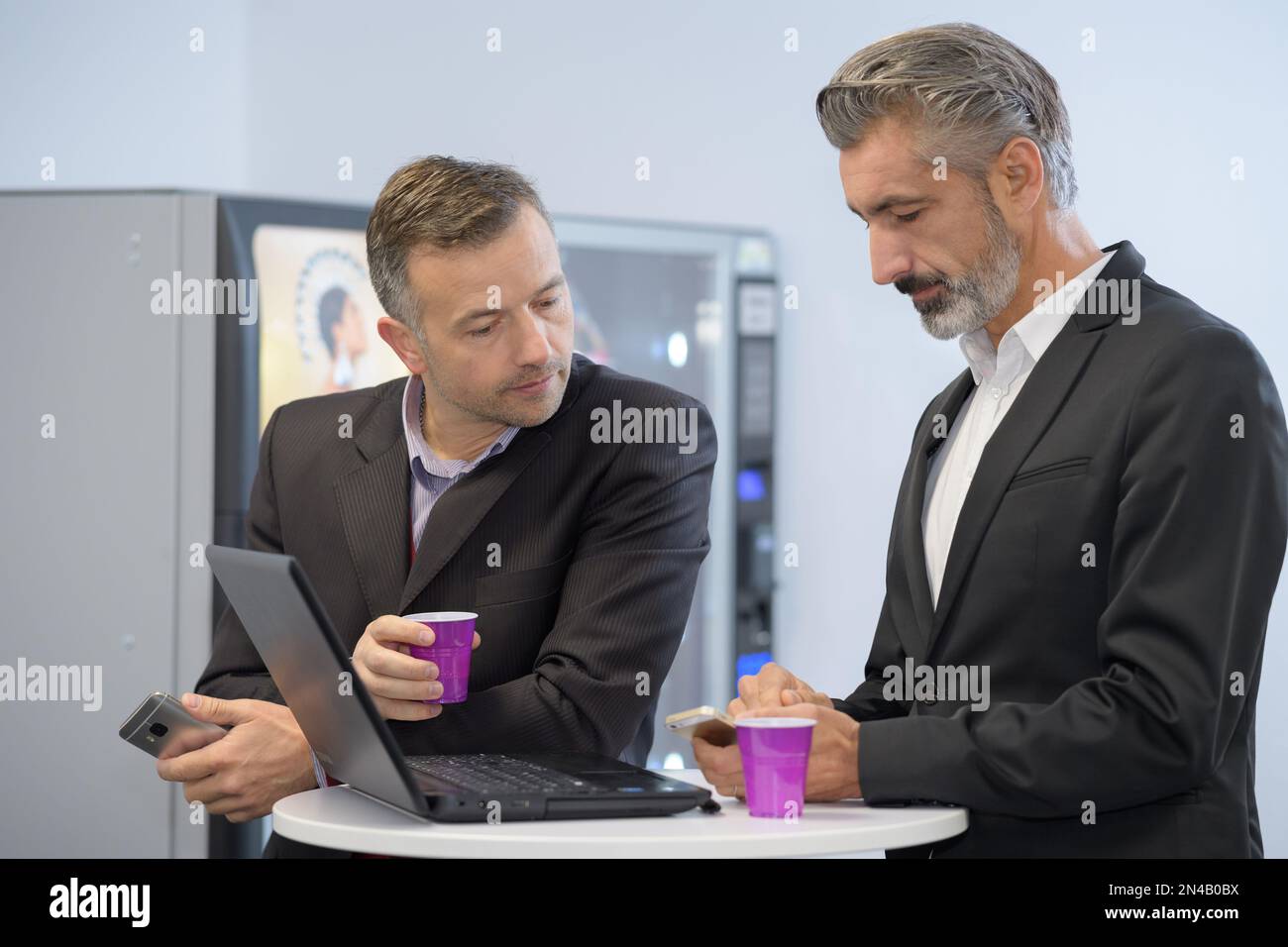 businessmen meeting up in a vending machine coffee pause Stock Photo ...