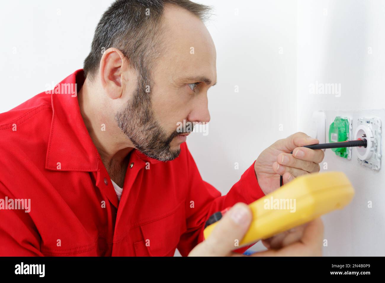 electrician testing plug socket with multimeter Stock Photo - Alamy
