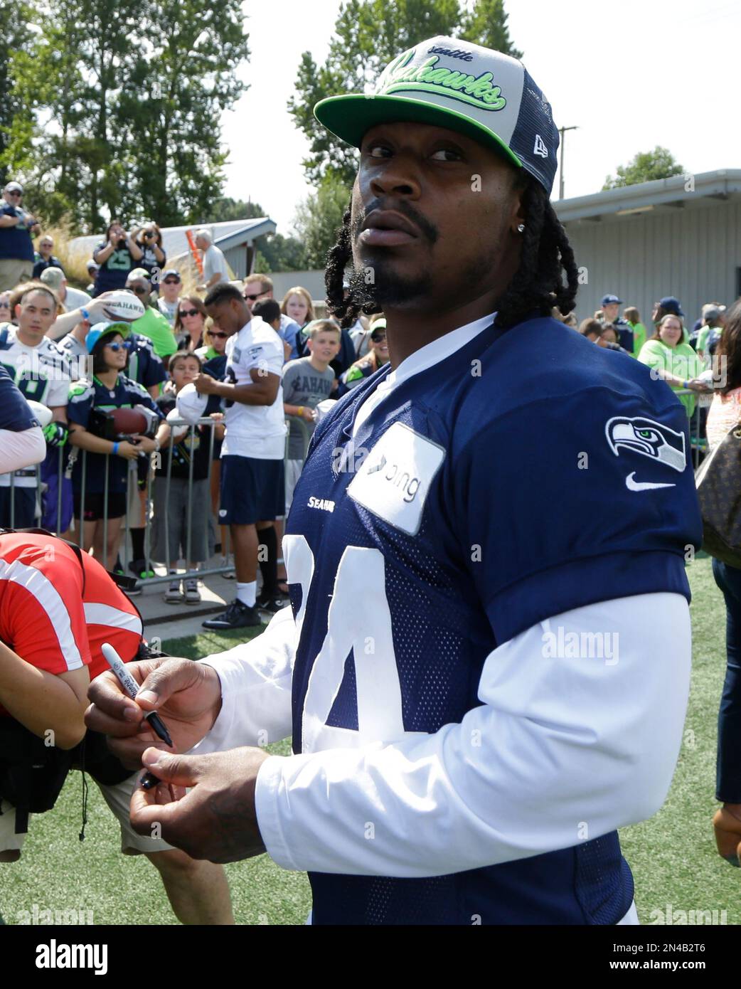 Seattle Seahawks running back Marshawn Lynch takes a break from signing ...