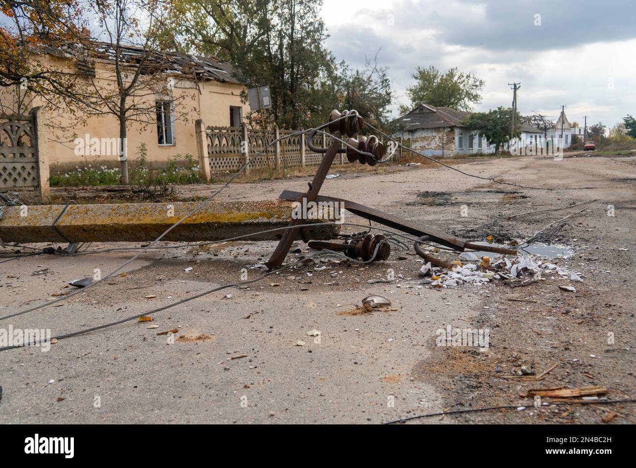 Countryside. Electrical pillar damaged by shelling lies on the ground ...