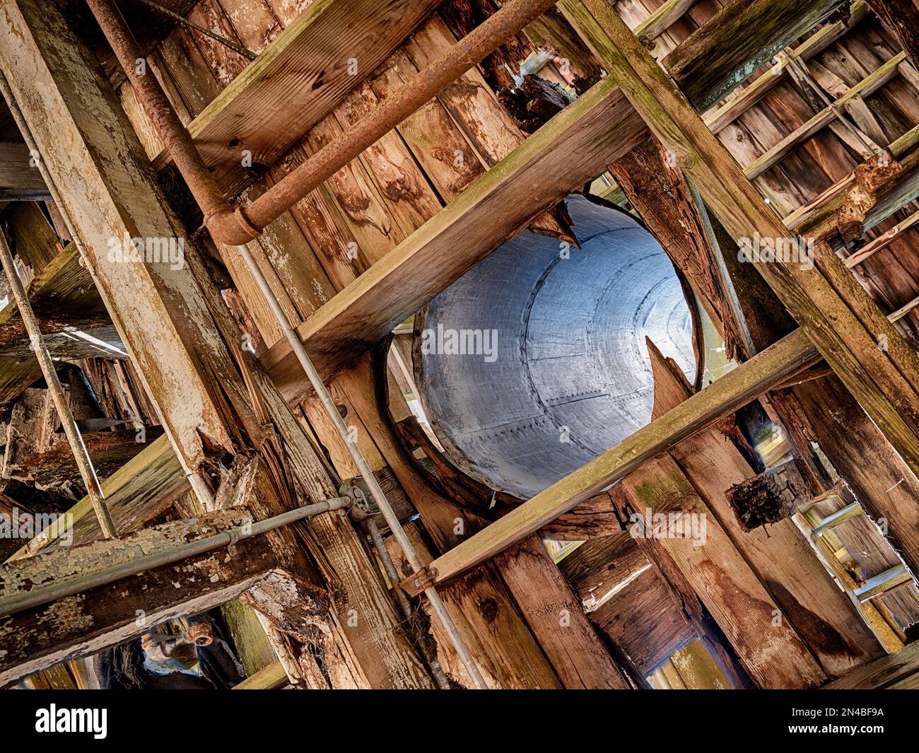 The steel kitchen chimney rises through the damaged ceiling and roof ...