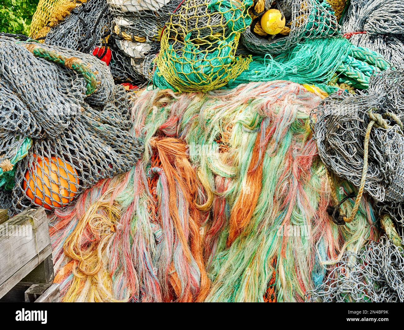 Fish nets made of colorful red, green and yellow threads are piled up ...