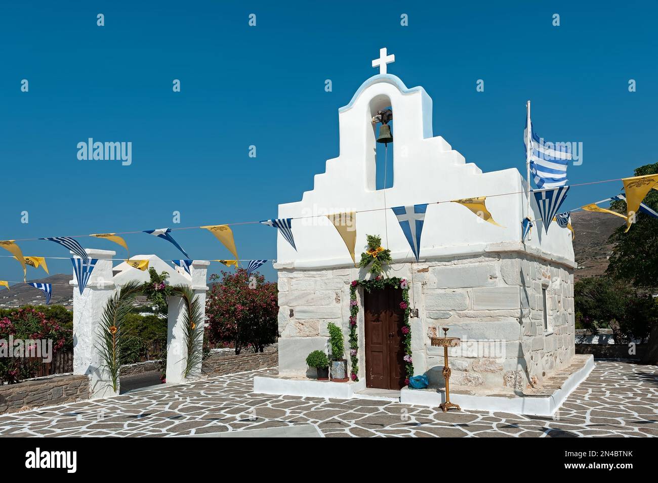 Small church with flower wealth and flags in Parikia, Paros, Cyclades ...