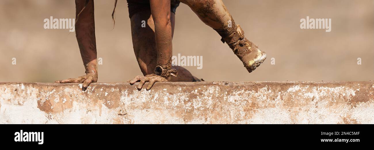 Mud race running. Running over obstacles female race participant ...