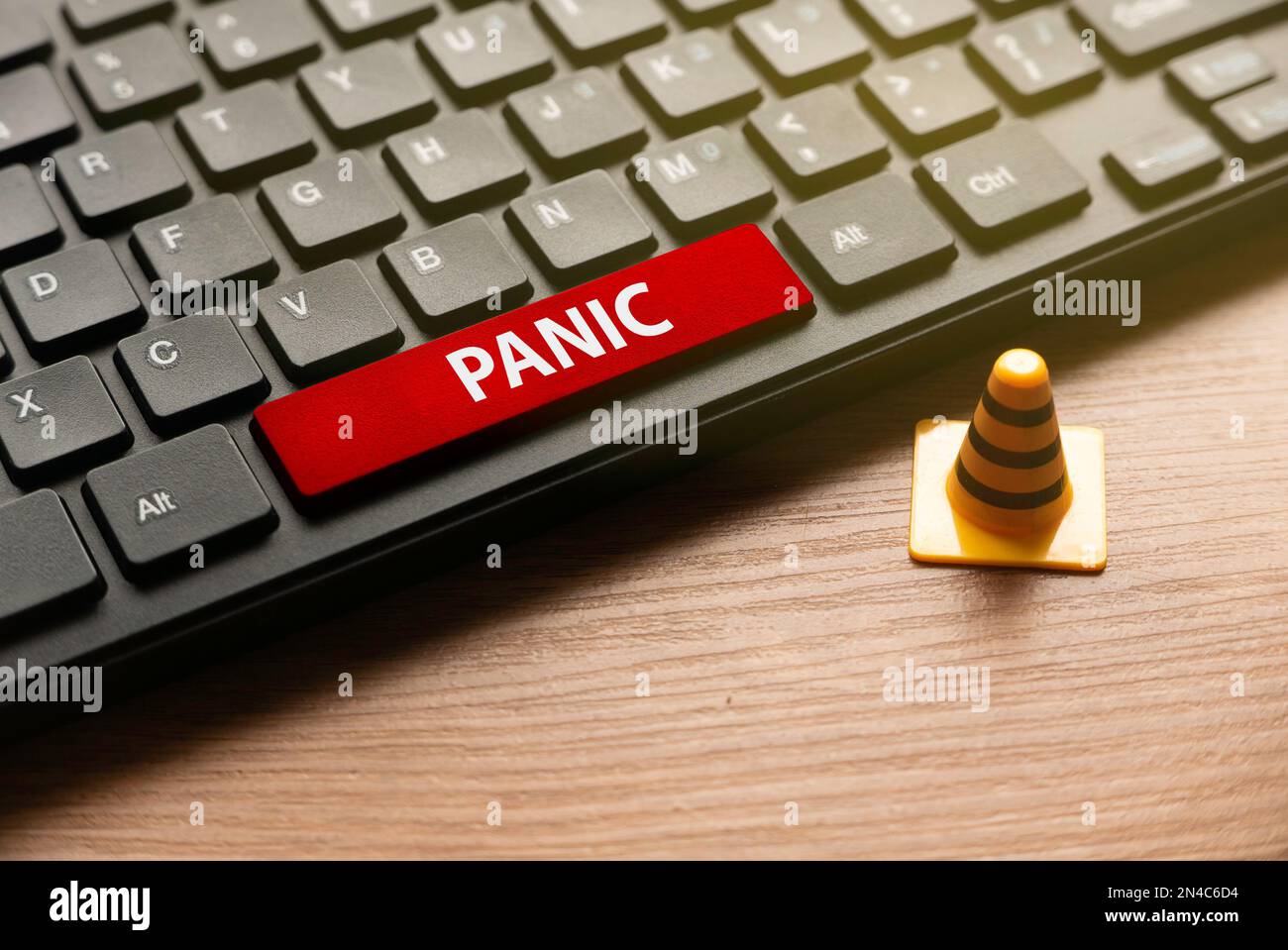 Yellow safety cone and computer keyboard with red button written with ...