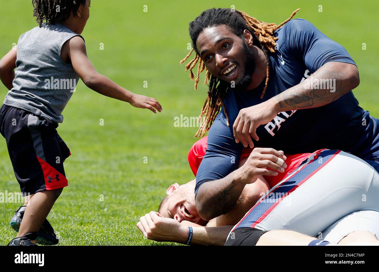 New England Patriots running back Brandon Bolden, top, looks to his son ...