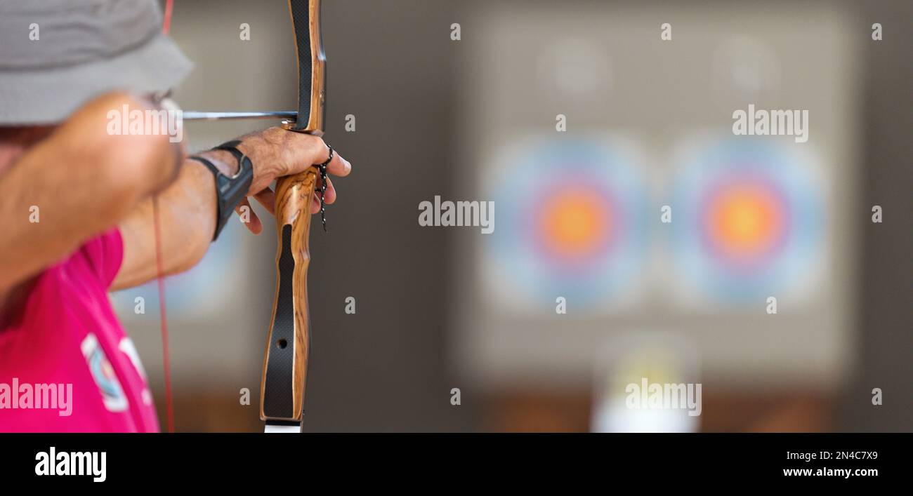Archer holds his bow aiming at a target, archery as a sport discipline ...