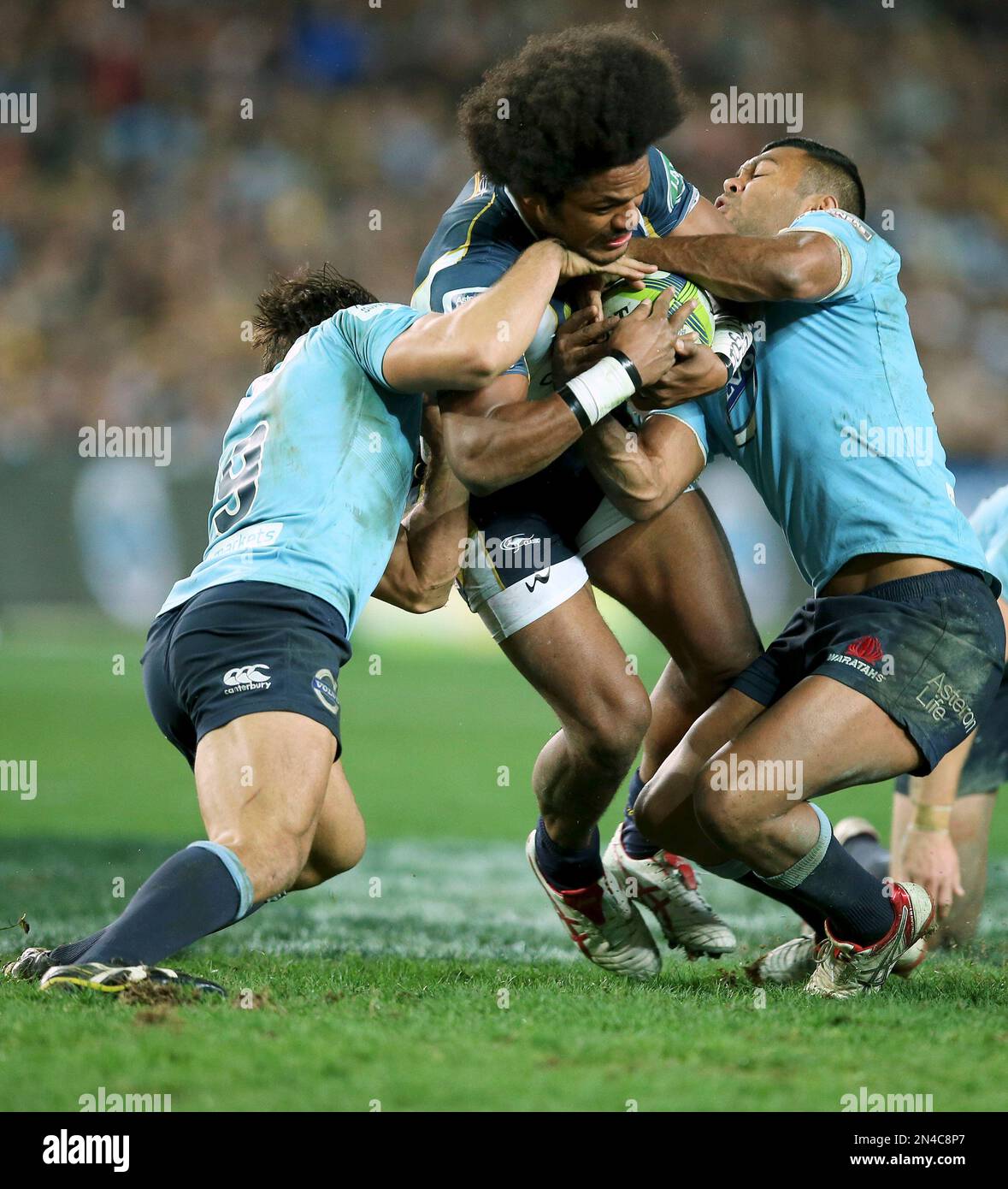 Brumbies' Henry Speight, center, pushes through the Waratahs' Nick ...