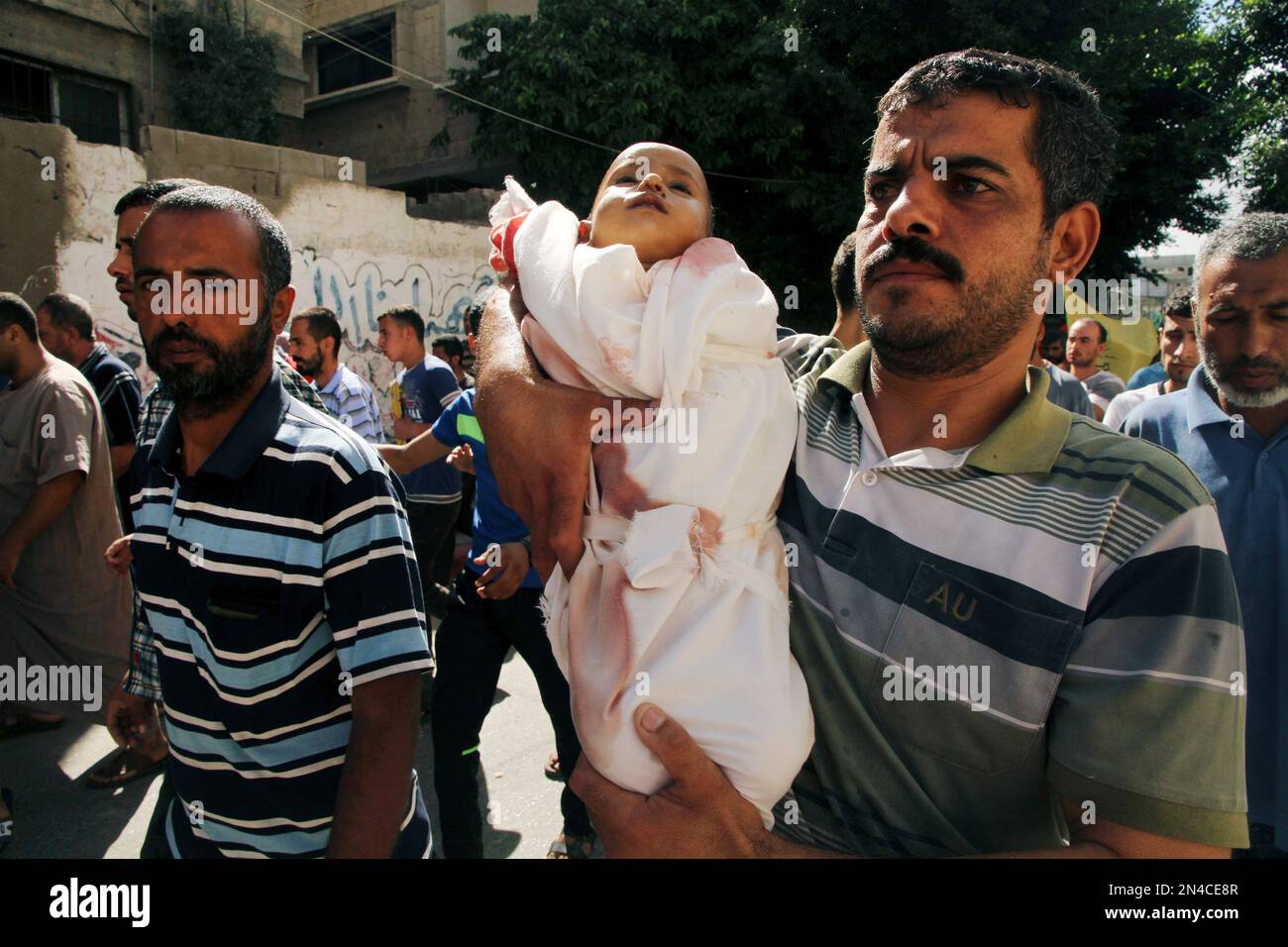 A Palestinian relative carries the body of 6-month-old Noha Mosleh, who ...