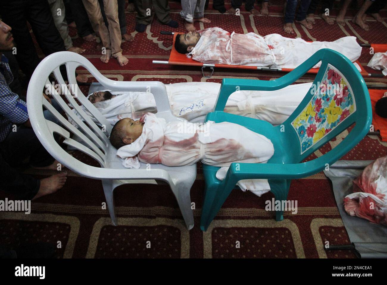 Palestinians gather around the body of 6-month-old Noha Mosleh and nine ...