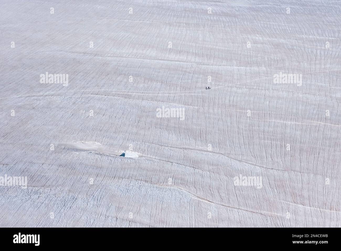Aerial view of two alpinists crossing the slopes of the upper part of ...