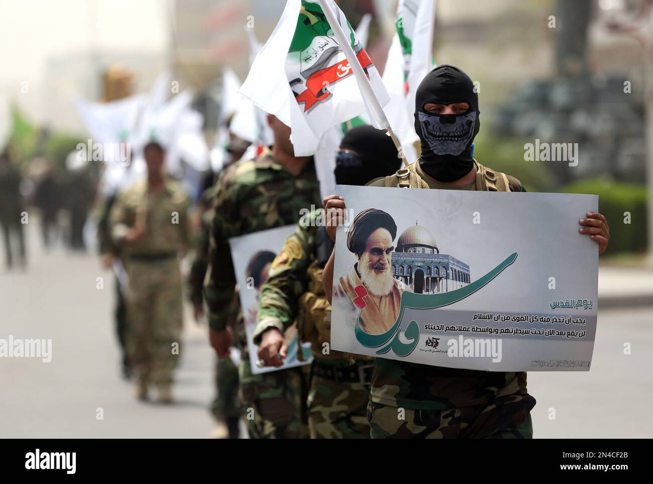 Supporters of Iraqi Hezbollah brigades march in military uniforms with ...