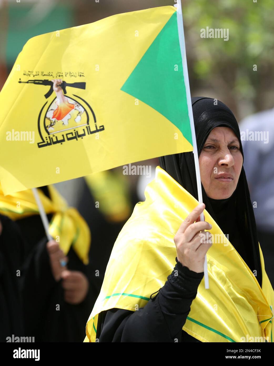 A female supporter of Iraqi Hezbollah waves the group's flag at a Quds ...