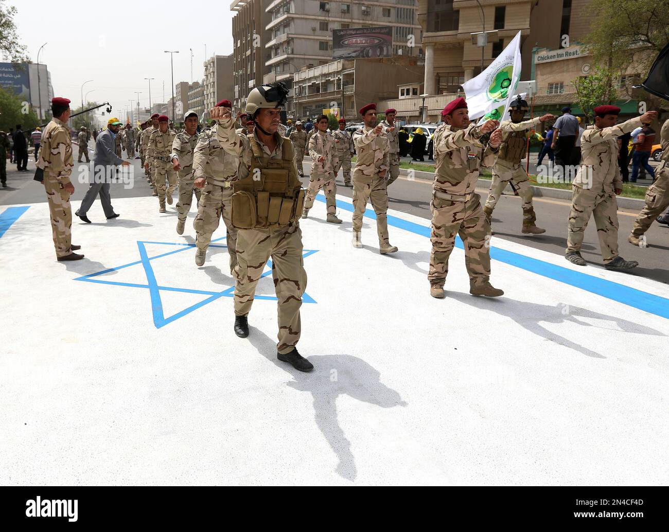 Supporters of Iraqi Hezbollah brigades marching in military uniforms ...