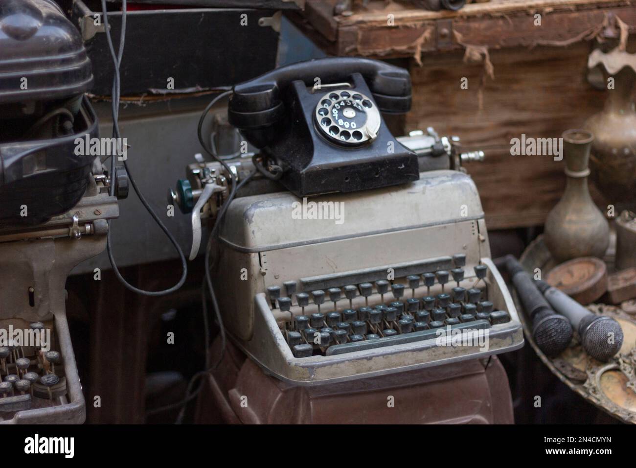 A typewriter and a phone are on display along with other old items ...