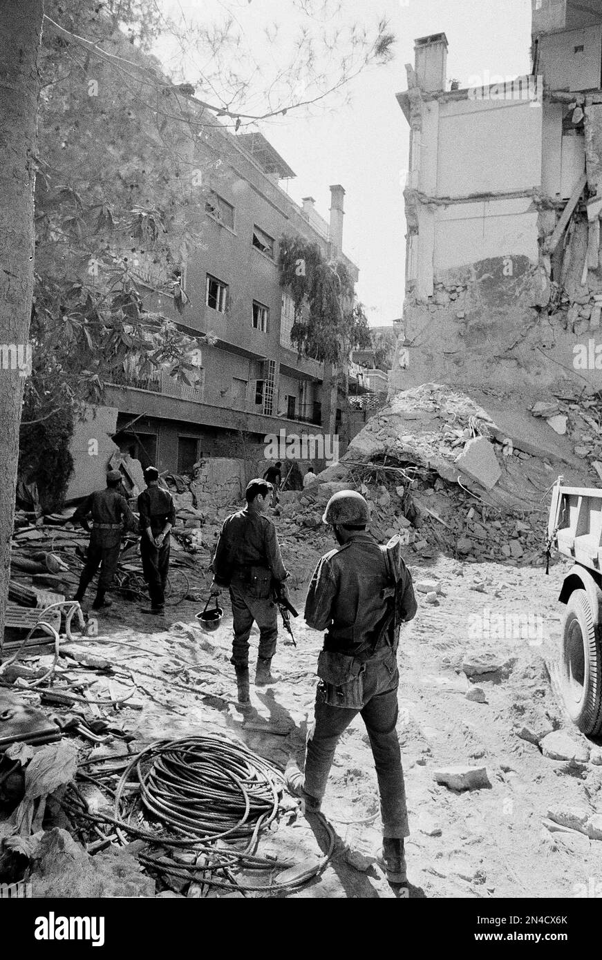 Syrian soldiers on patrol against looters in a bombed-out residential ...